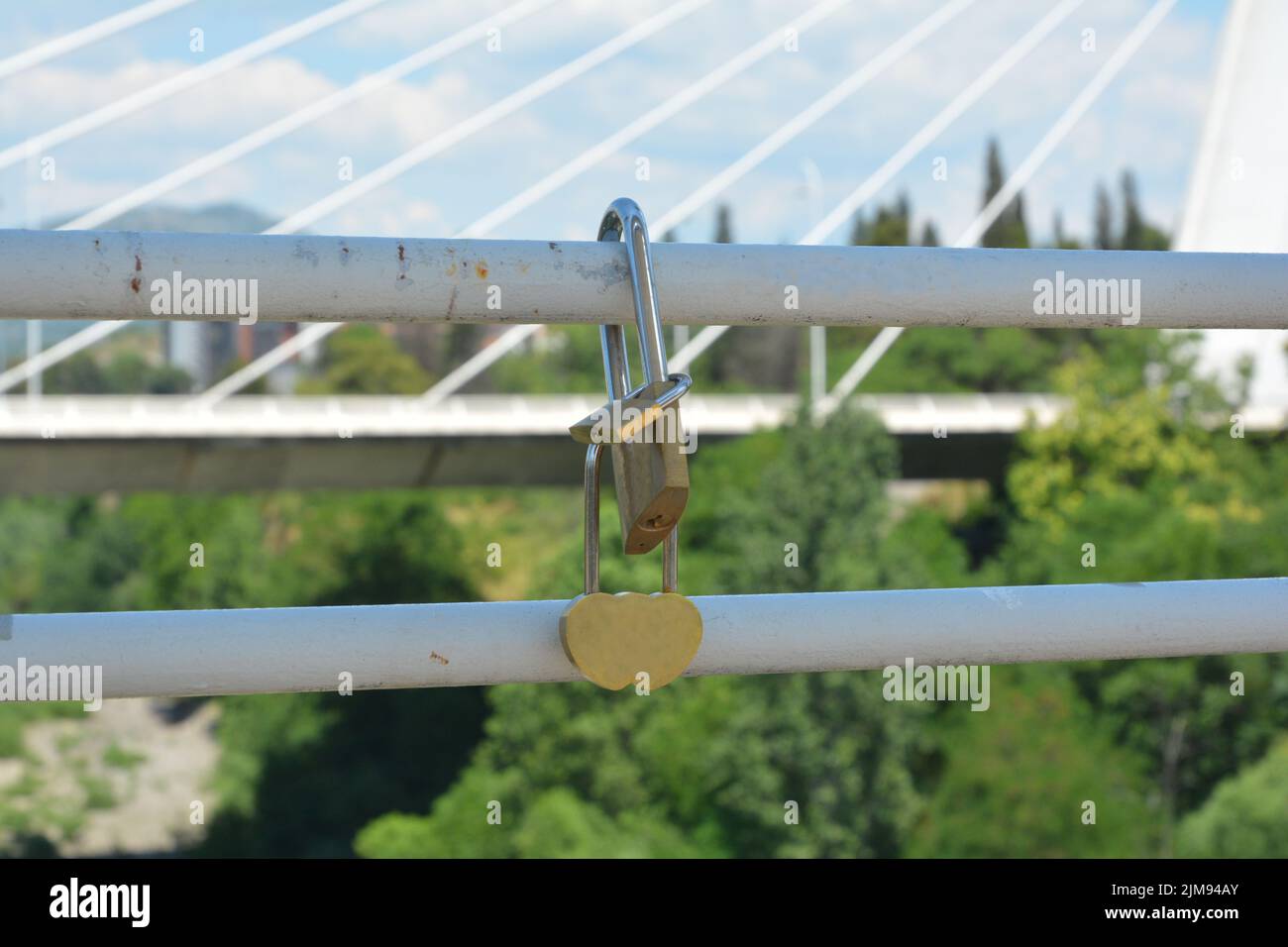 a lock on a metal bridge handle with an another bridge in background ...