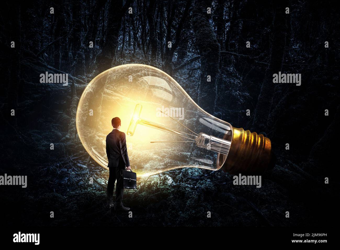 Huge light bulb glowing in the darkness Stock Photo - Alamy