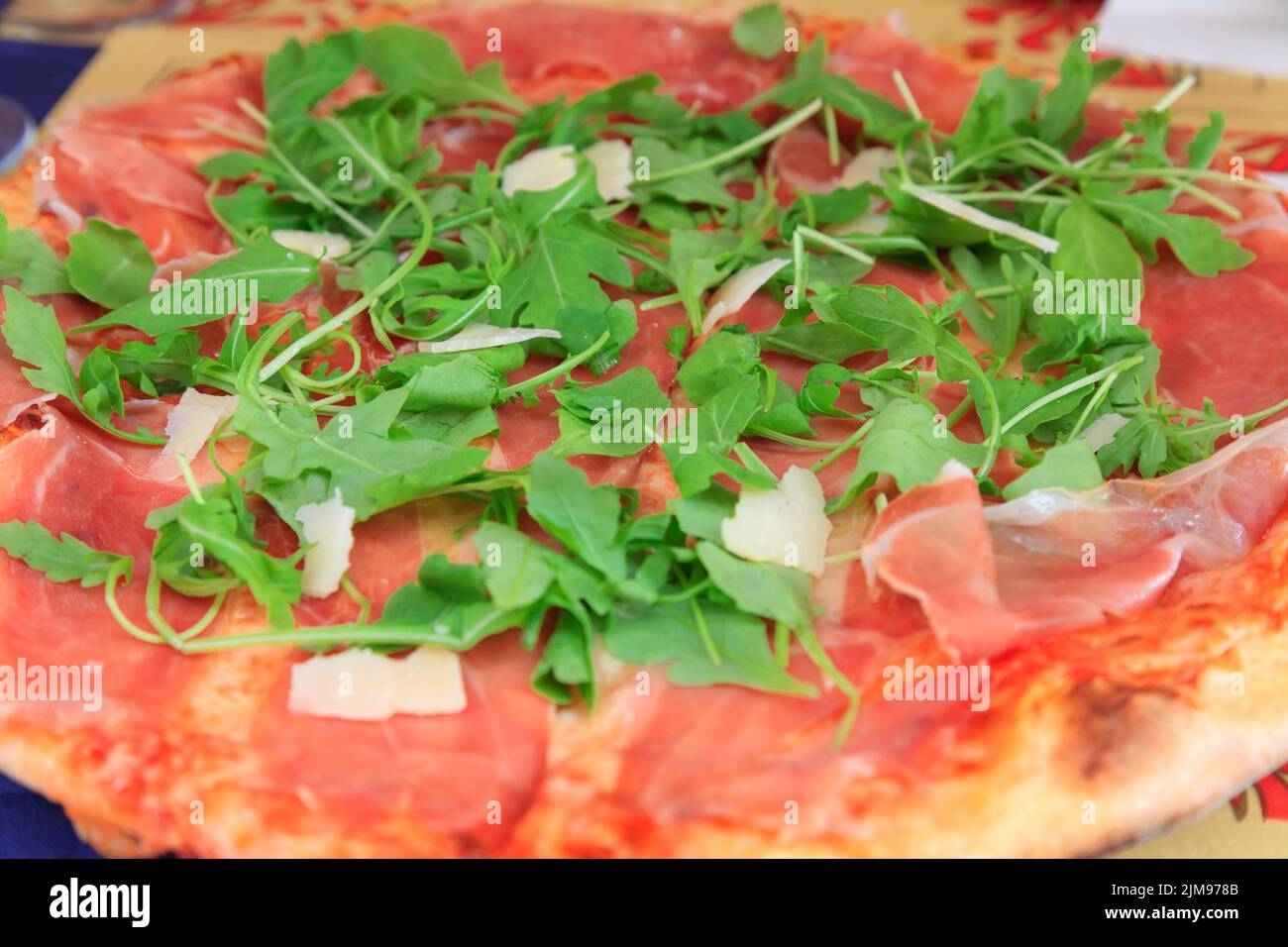Italian pizza with parmesan, rucola and prosciutto Stock Photo - Alamy