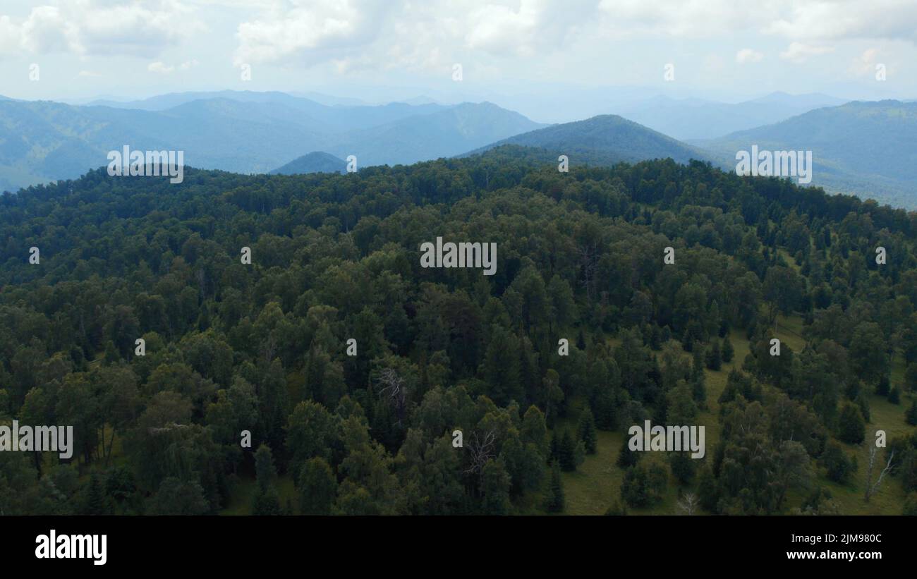 Mountains and green forest from peak of Manzherok under white clouds ...