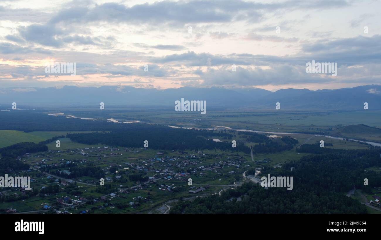 Aerial of valley in Altai and country houses under sunset sky, Siberia ...