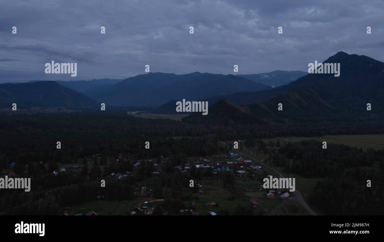 Aerial of valley in Altai and country houses under sunset sky, Siberia ...
