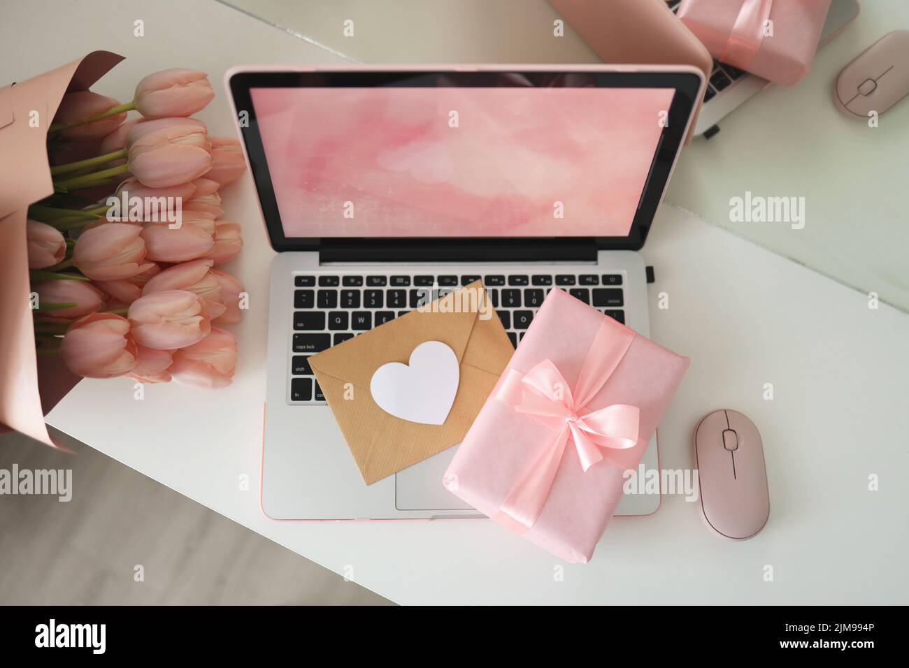 Styled feminine desk workspace with pink tulips, laptop computer and ...