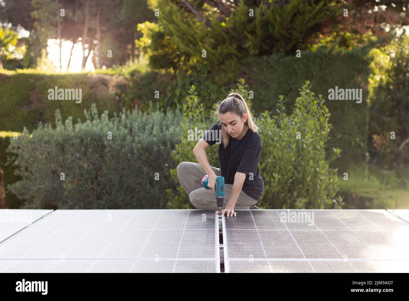 Young woman working on a solar panel installation to get renewable ...