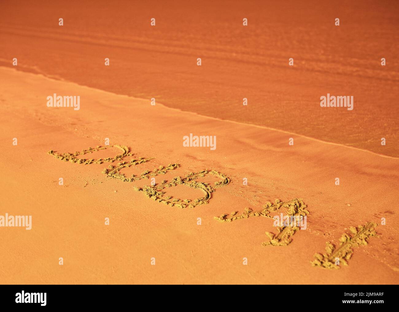 Dubaiu written on sand Stock Photo - Alamy