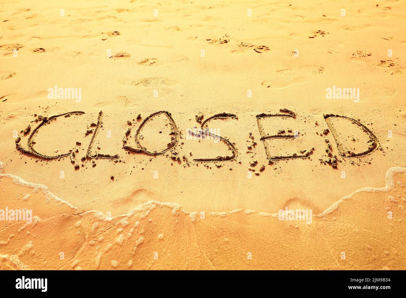 Closed written on sand Stock Photo - Alamy