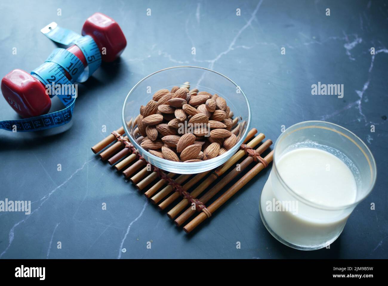 dumbbell, almond nut and milk on black background Stock Photo - Alamy