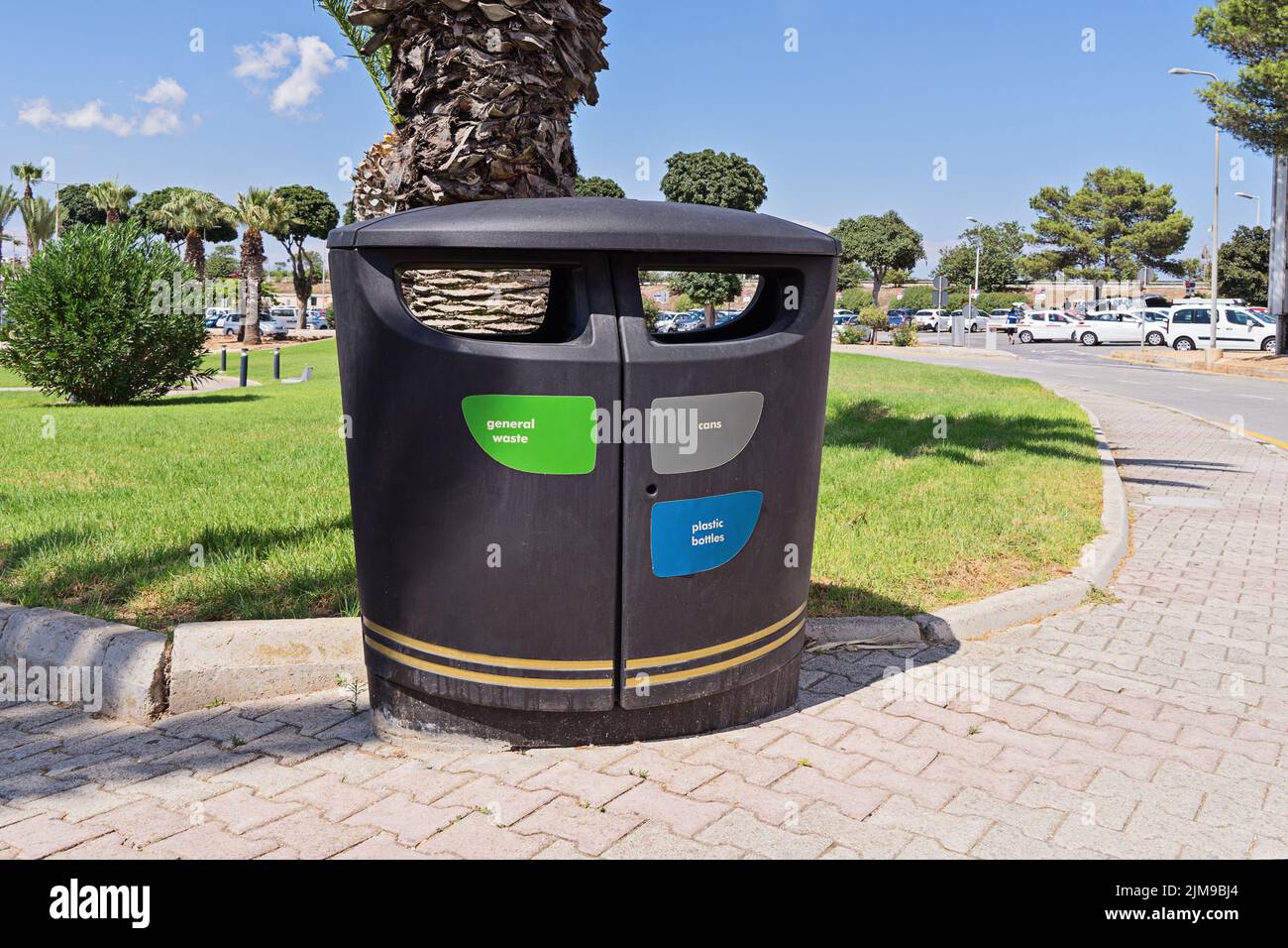 Modern litter bin with sections for sorting rubbish in public place ...
