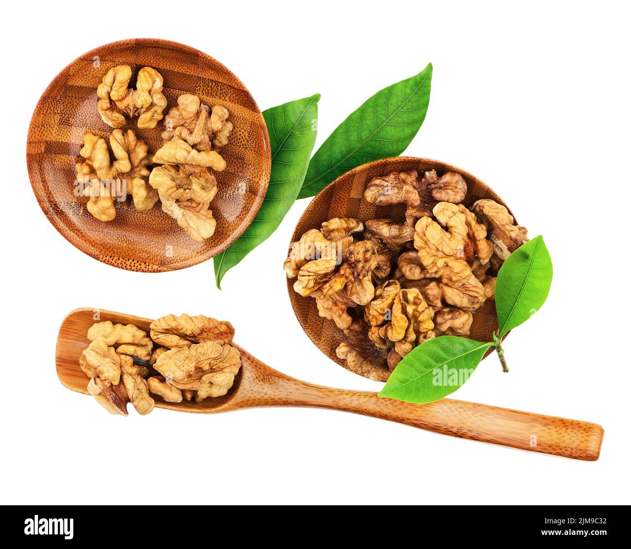 Handful of walnuts in wooden bowls, scoop and green leaves Stock Photo ...