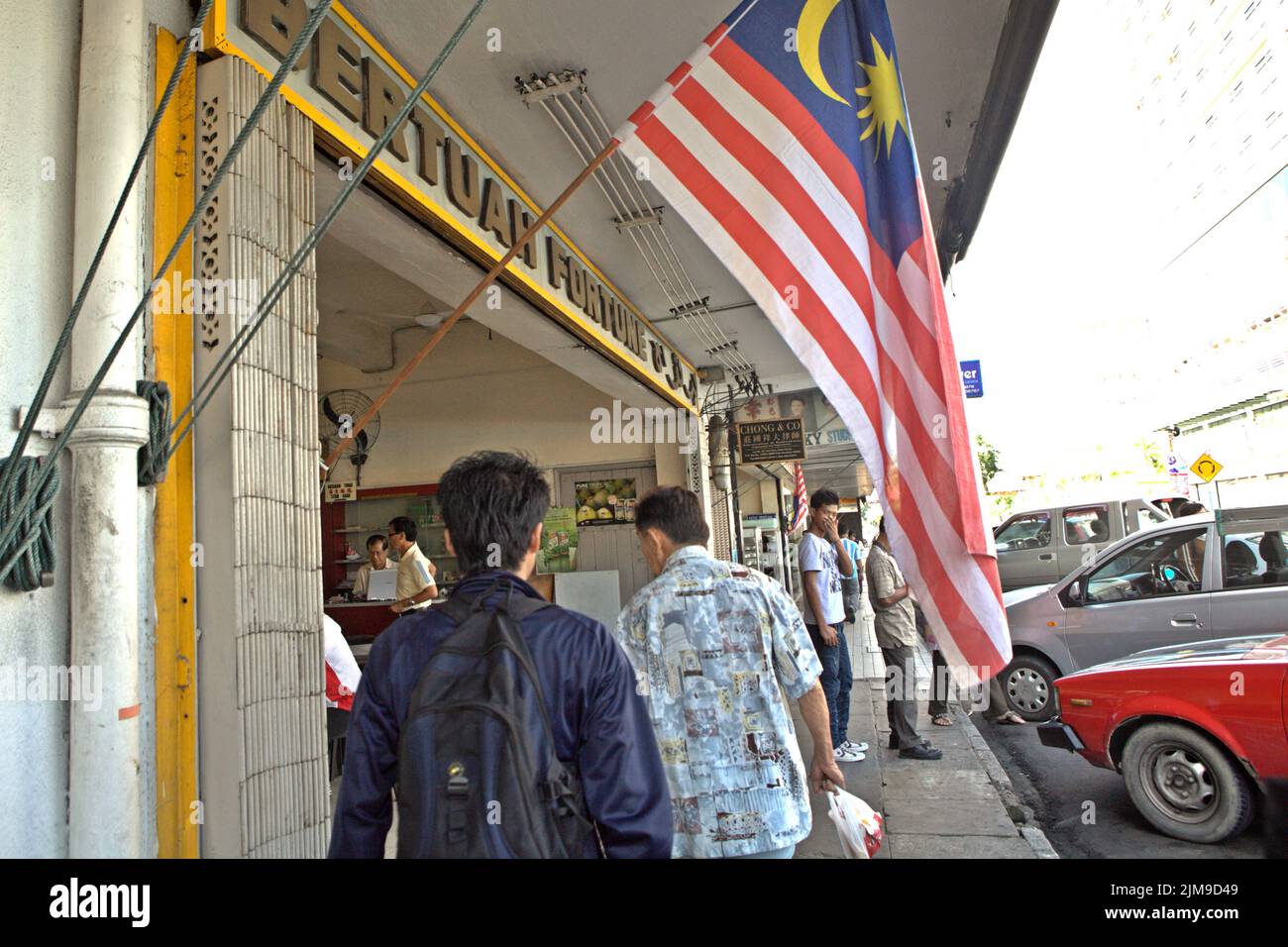 People walking and standing on a roadside walkway at a commercial area ...