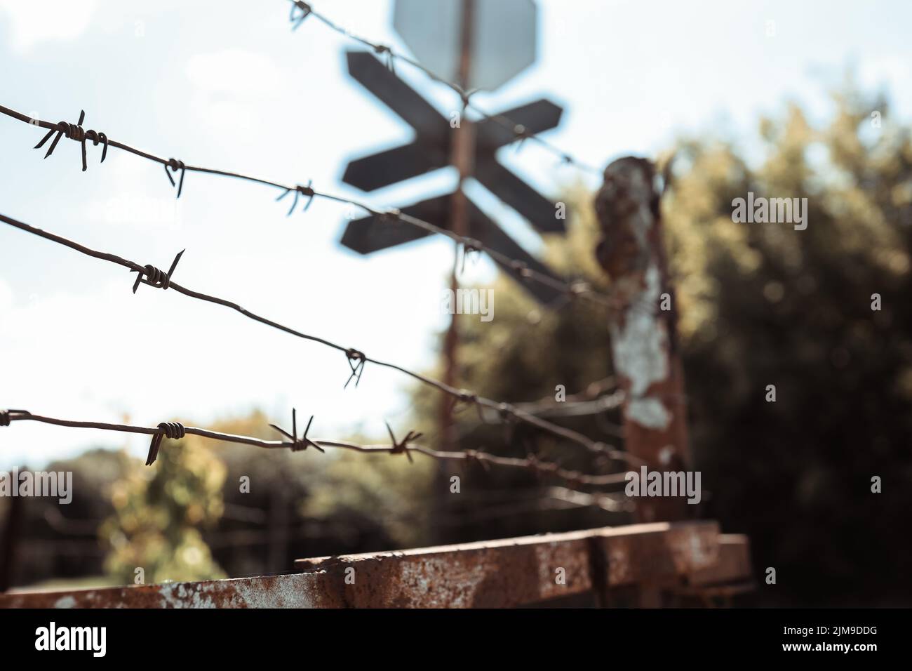 Barbed wire fence against dramatic, dark sky. City road street sign ...