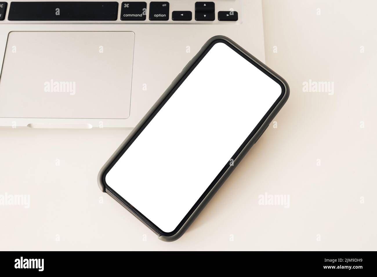 Close up smart phone and computer on white table top view. White screen ...