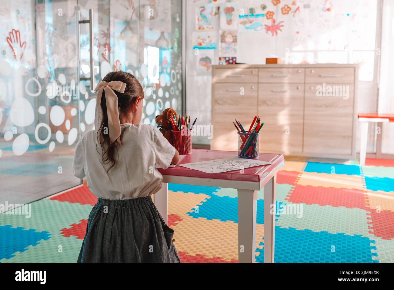 Little girl drawing with color pen in paper on table at playroom, Baby ...