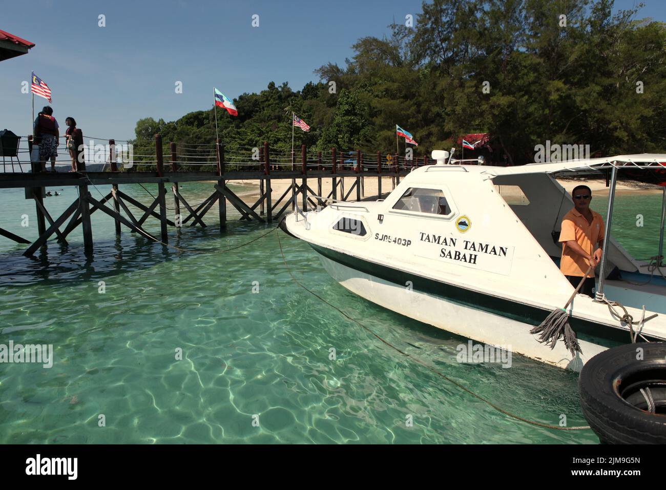 A tourist boat on the coastal water of Pulau Sapi (Sapi Island), a part ...