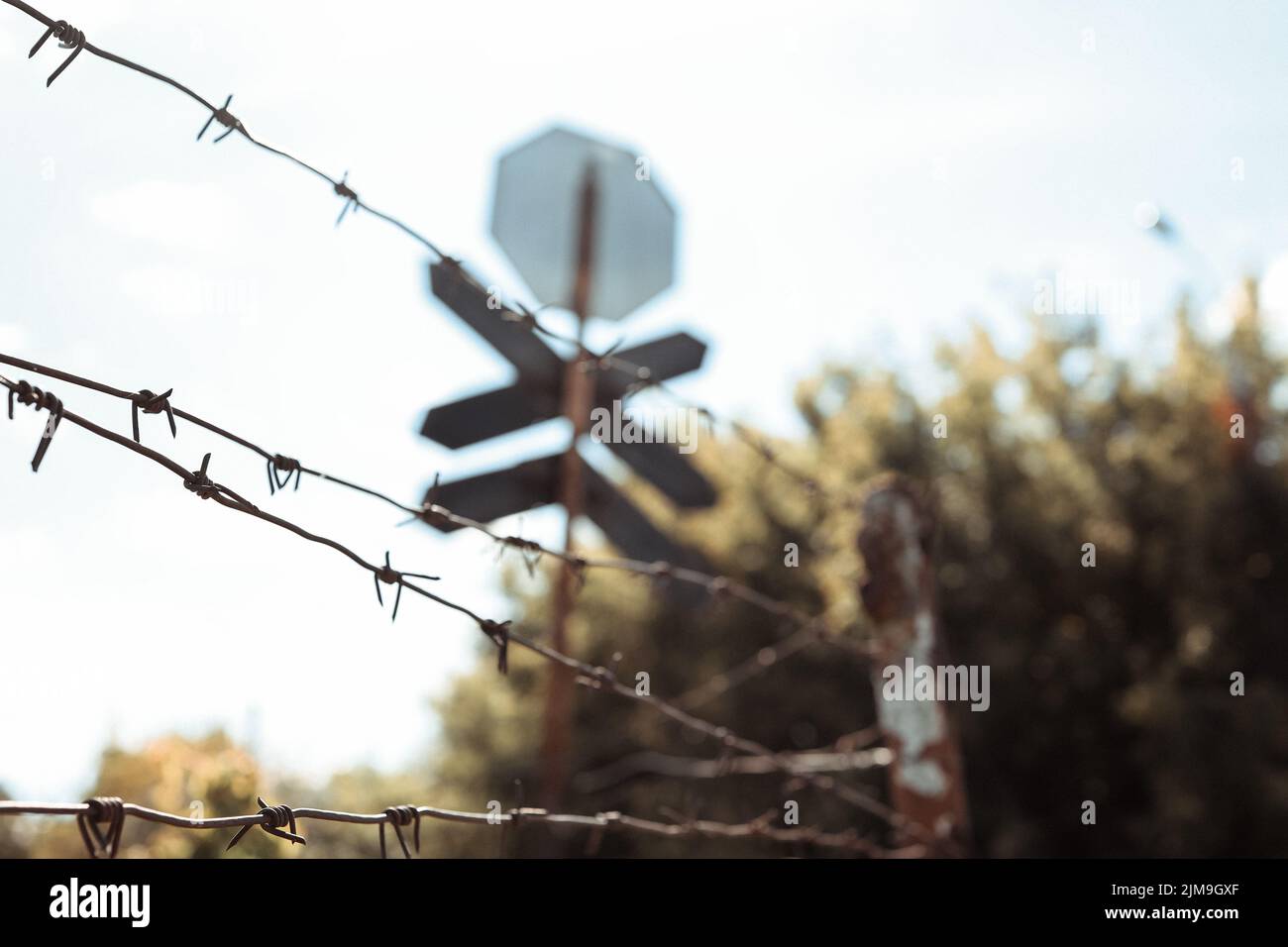 Barbed wire fence against dramatic, dark sky. City road street sign ...