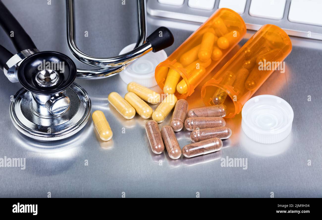 Capsules and medicine bottles plus medical equipment on stainless steel ...