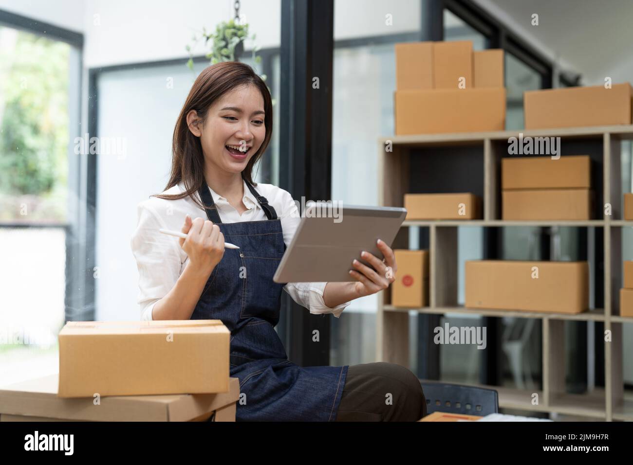 Success asian woman with her hand lift up, online marketing packaging ...