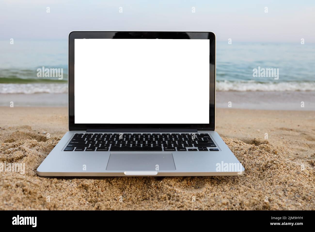 Laptop on sand at summer beach in background with white screen Stock ...