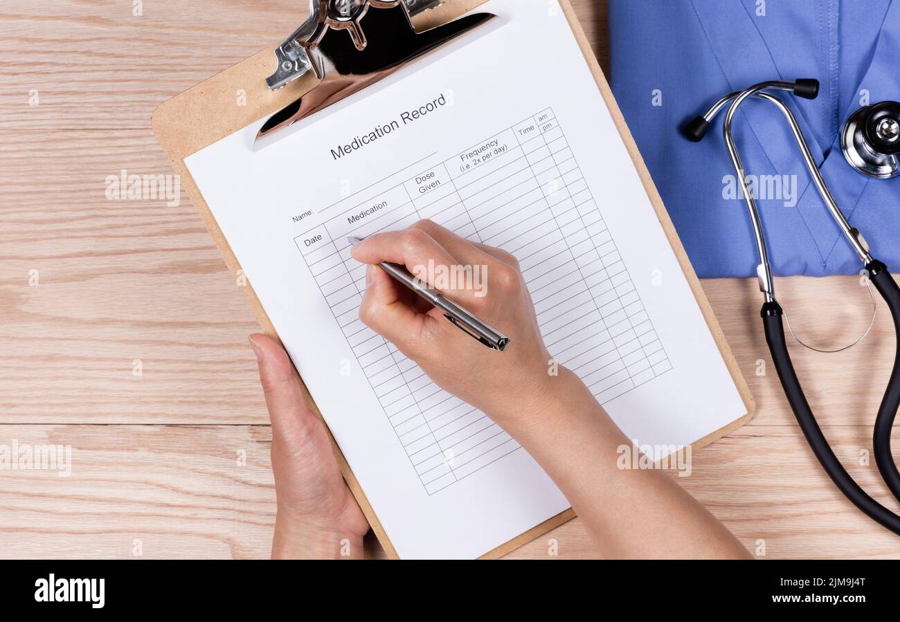 Doctor working on patient medication form with medical objects on ...