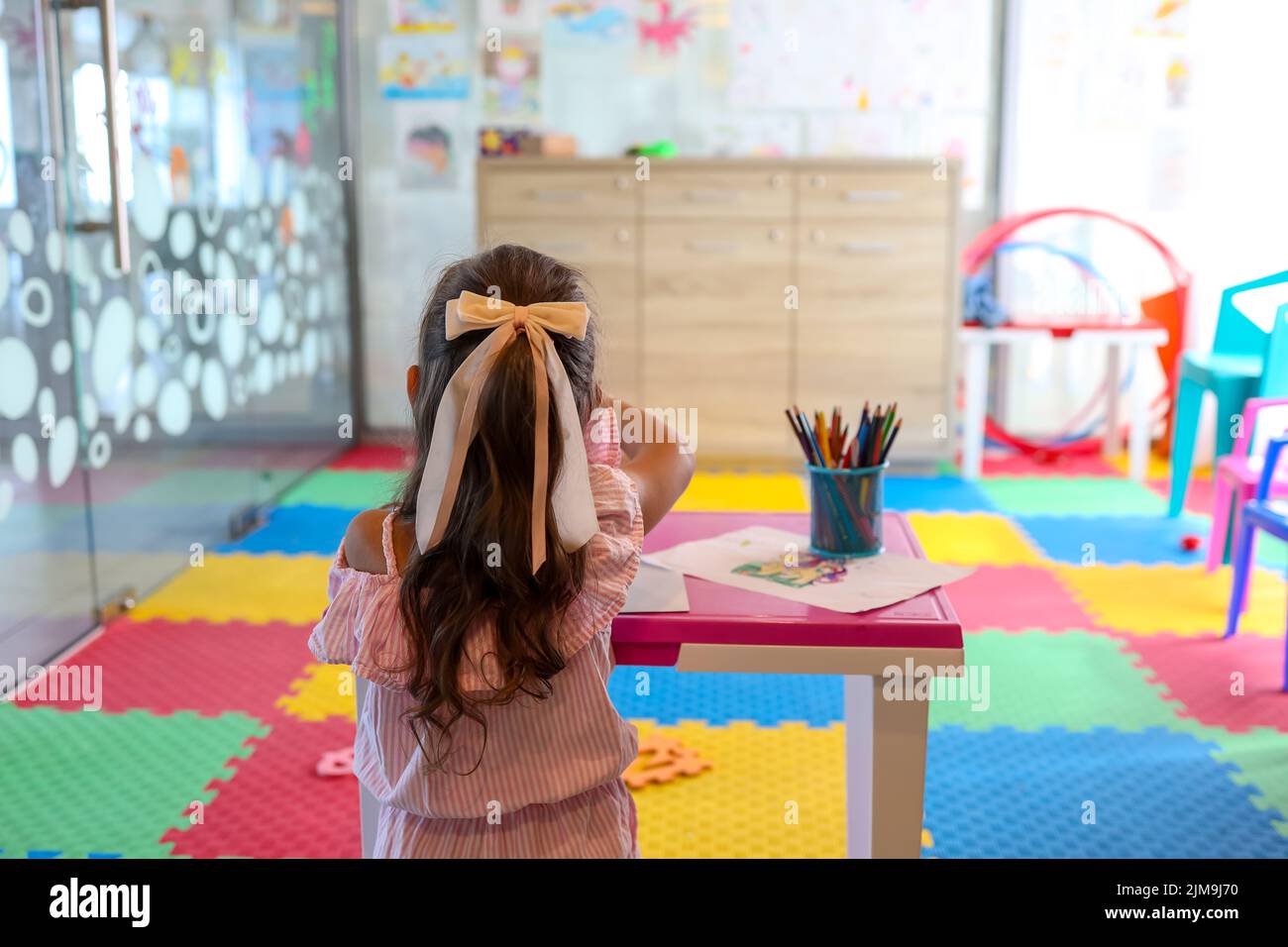 Little girl drawing with color pen in paper on table at playroom, Baby ...
