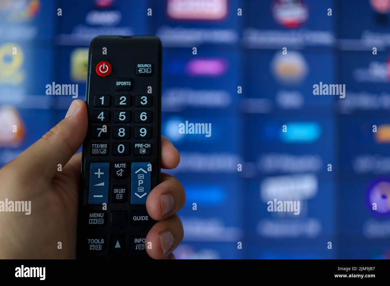 Smart tv and hand pressing remote control. Hand holding TV remote ...