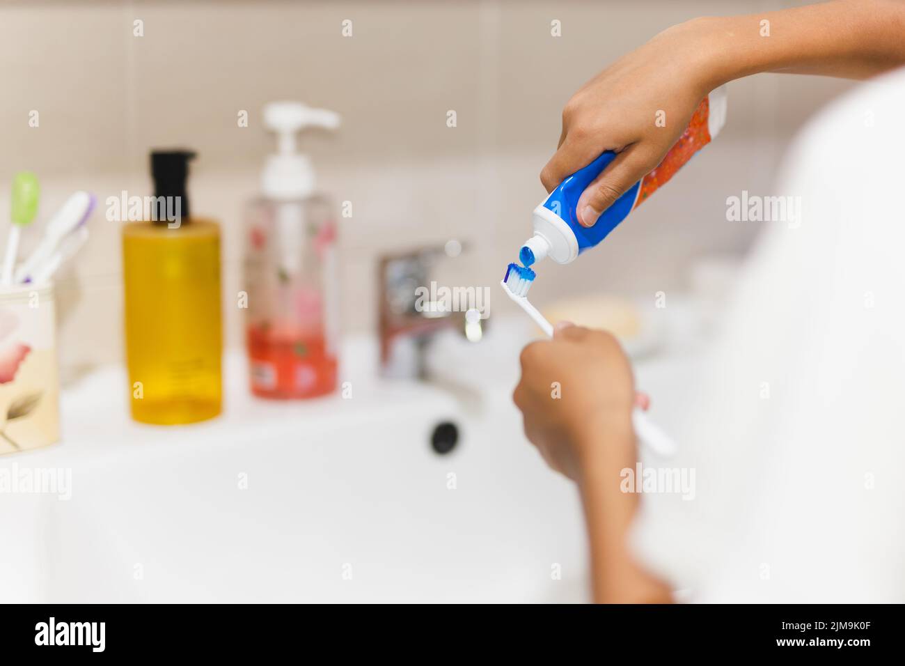 Boy hand putting toothpaste on toothbrush in the bathroom Stock Photo ...