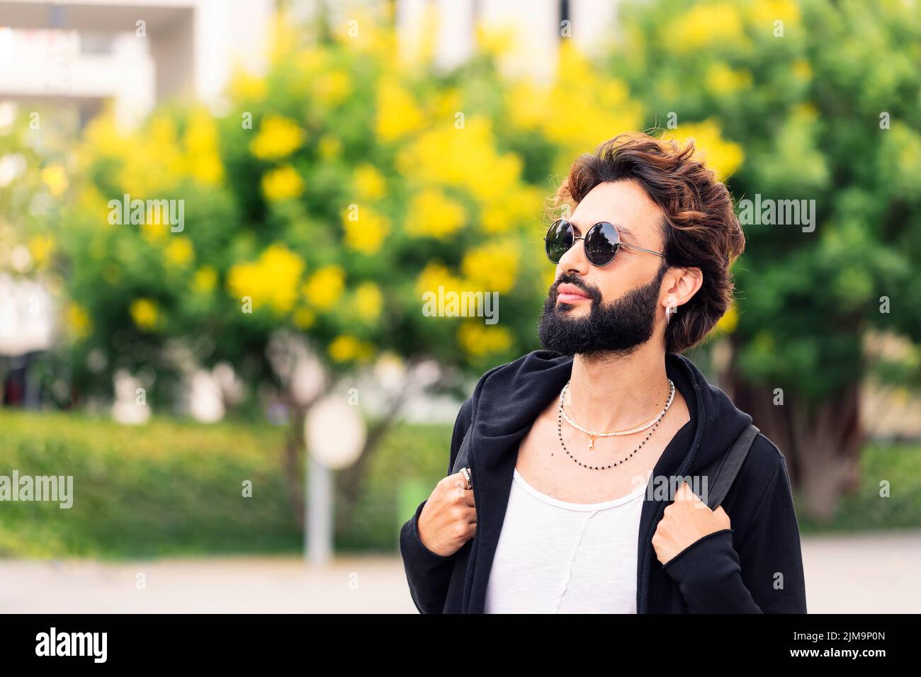 portrait of a stylish young college student with beard and sunglasses ...