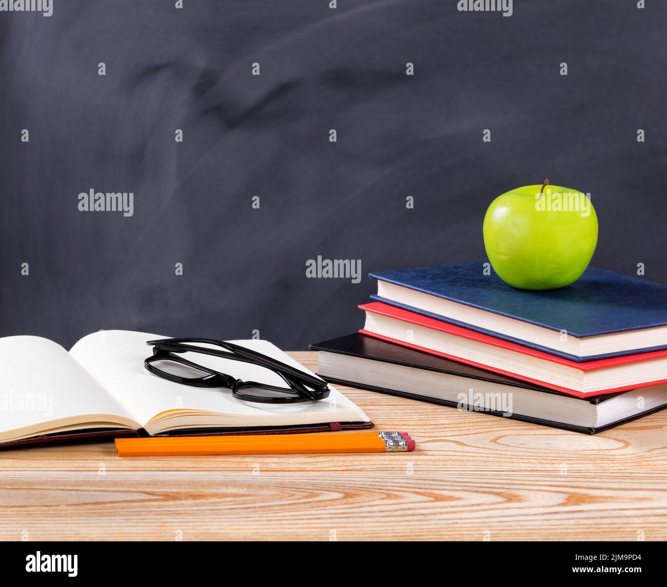 Back to school desk with stationery objects in front of erased black ...