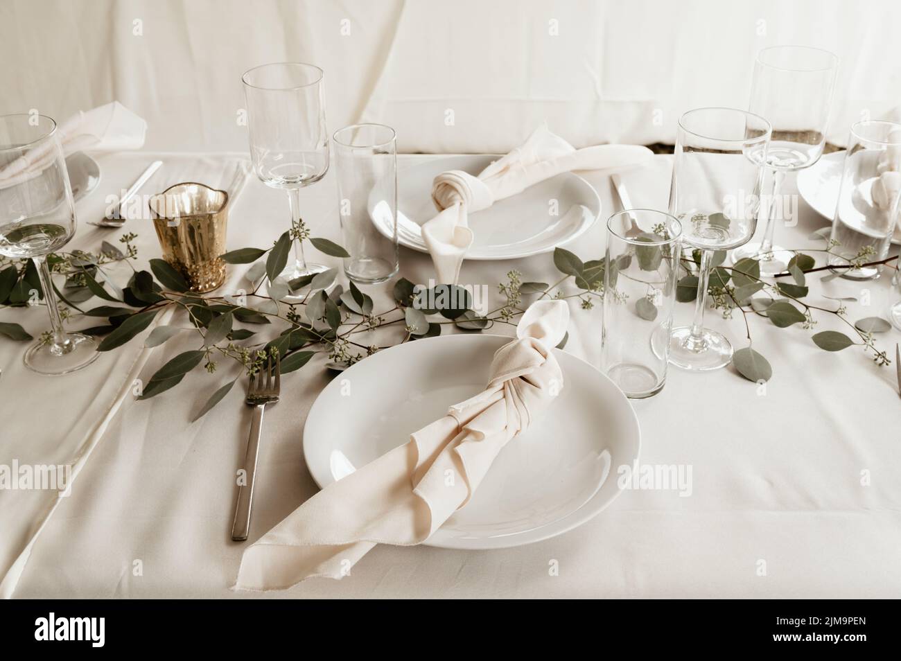 A white table with dishware and wedding decorations at the restaurant ...