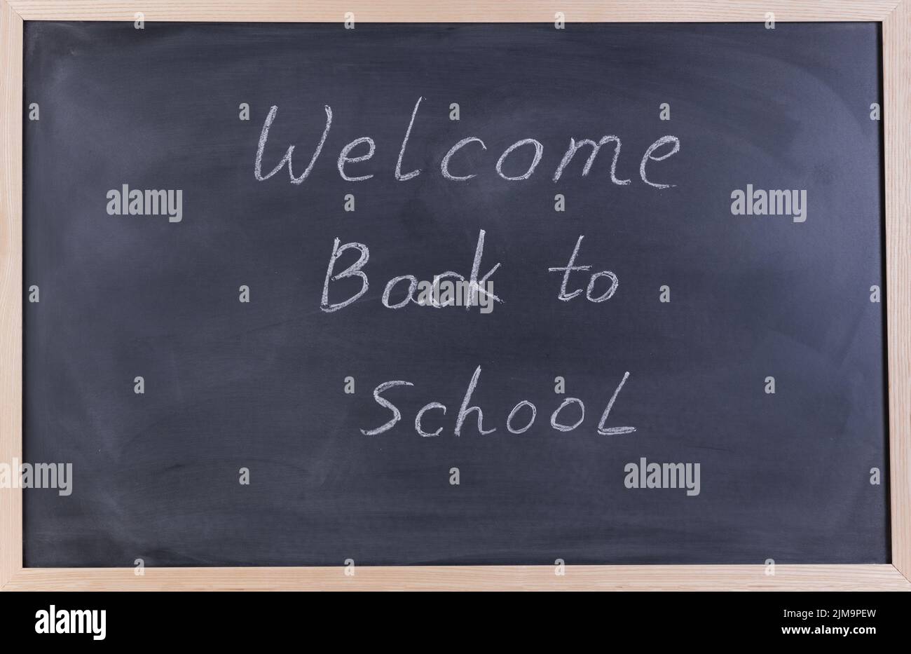 Erased black chalkboard with welcome back to school message for ...