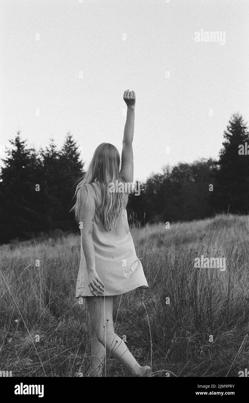 A grayscale shot of a woman dancing in the field - happy and free Stock ...
