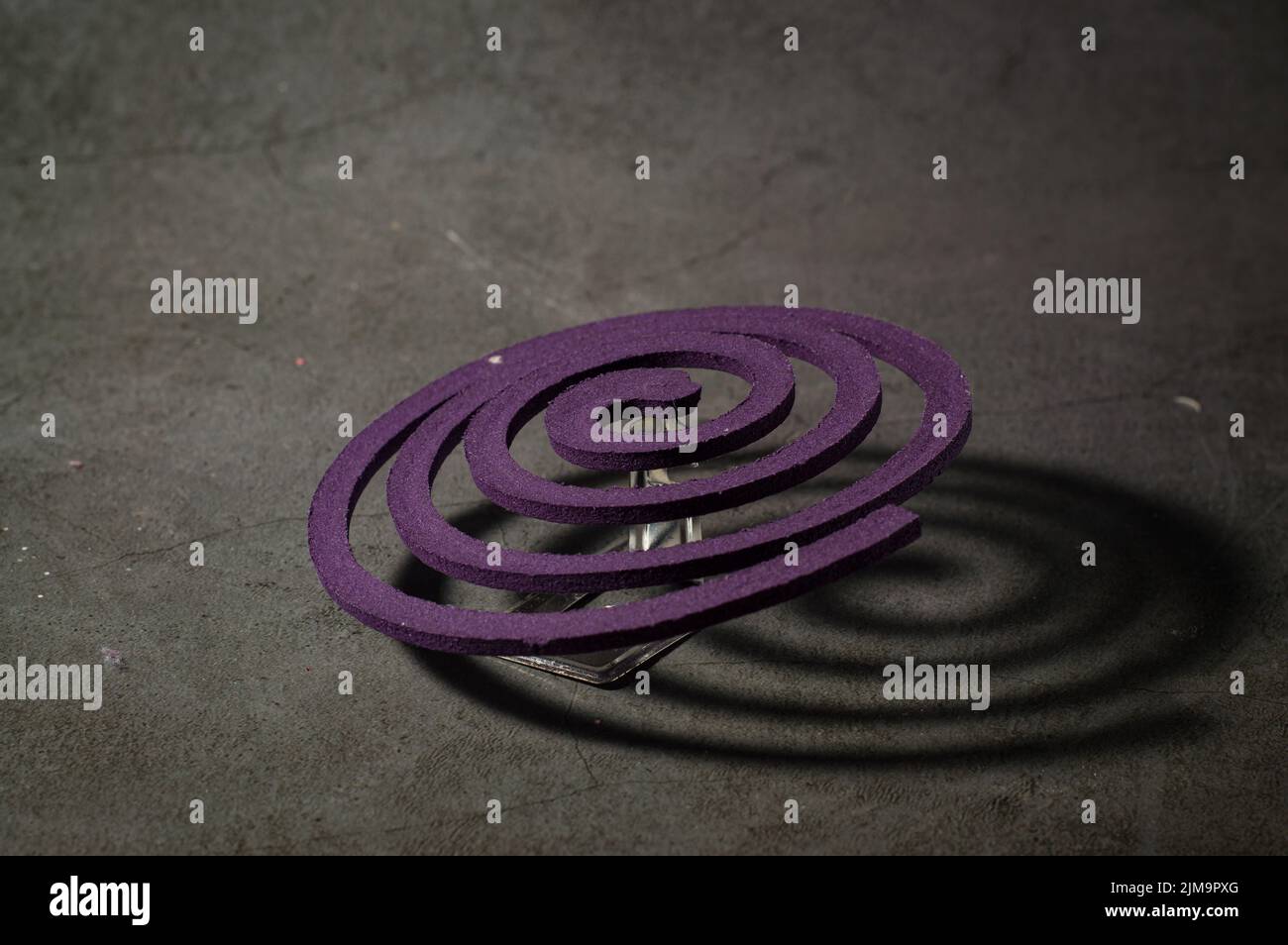 A closeup shot of a purple Mosquito coil to fight mosquitoes with its ...