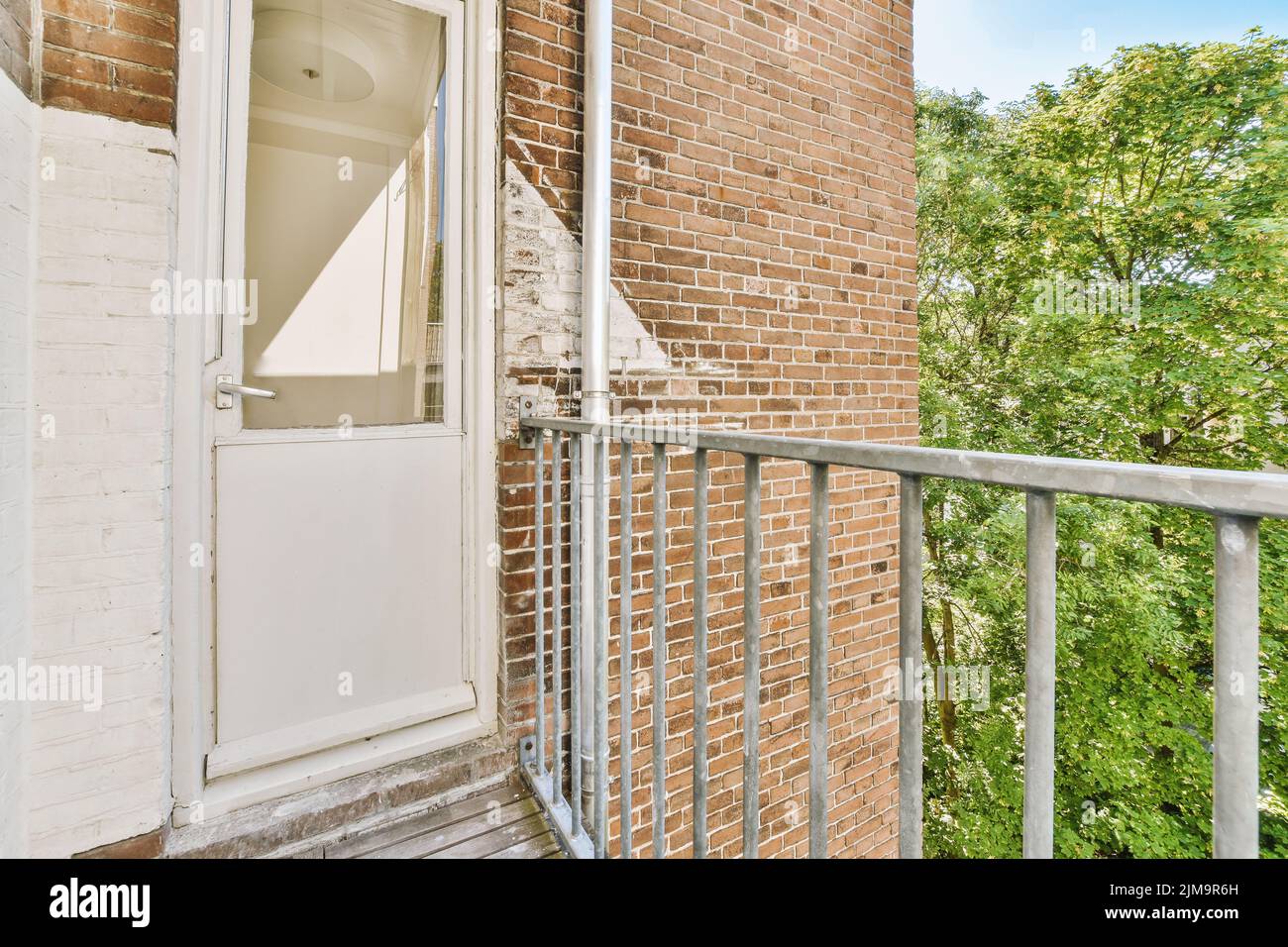Narrow brick balcony with metal railings and door Stock Photo - Alamy
