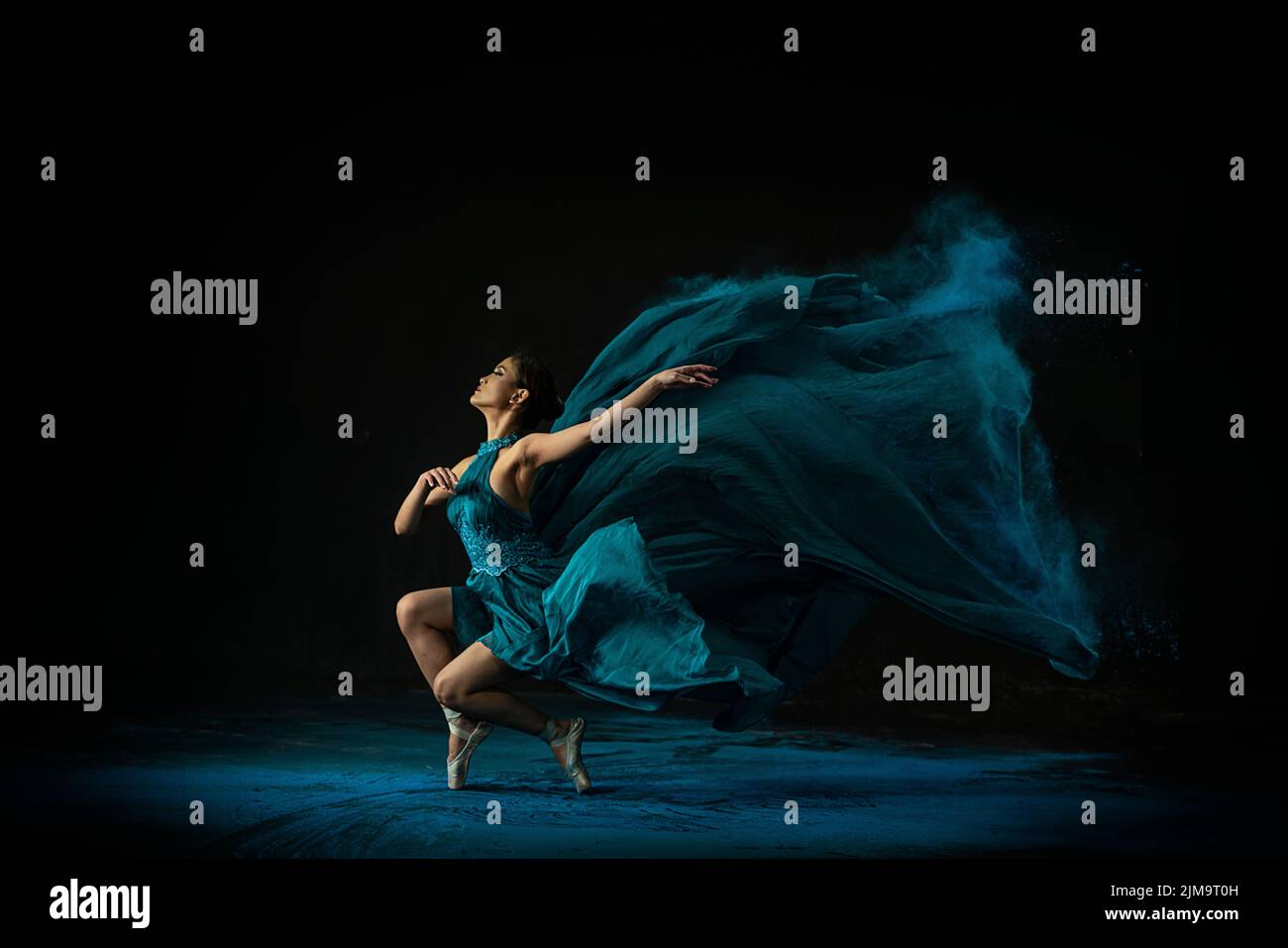 An emotional Southeast Asian ballet dancer in a green dress with powder ...