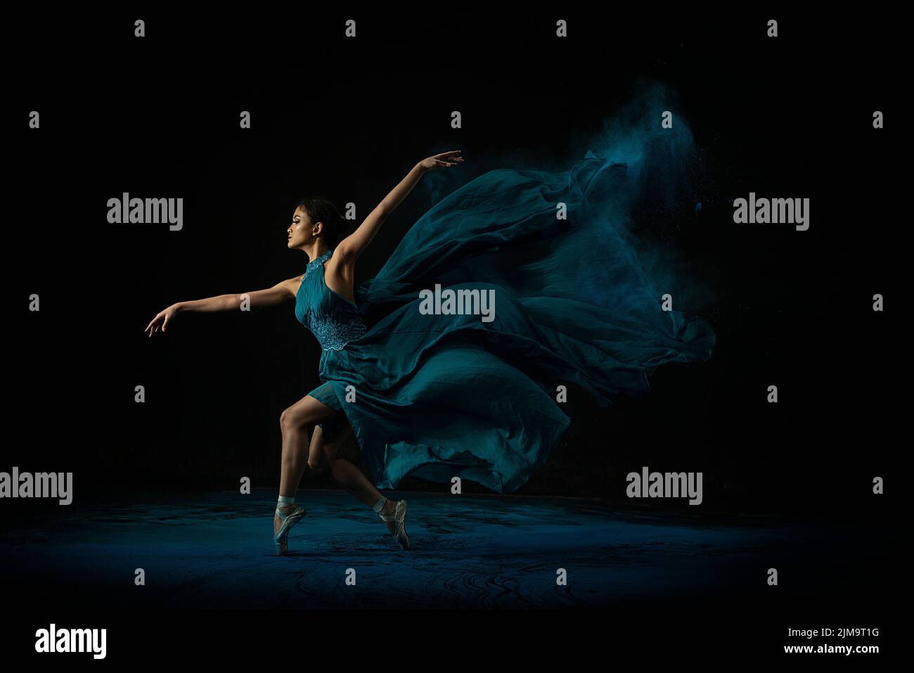 An emotional Southeast Asian ballet dancer in a green dress with powder ...