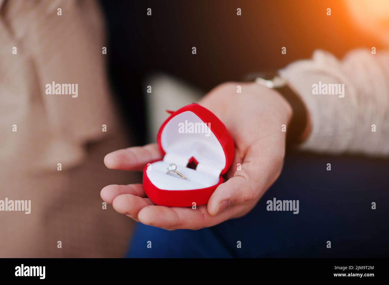 Marriage proposal. Man hold engagement ring at red box in his hand ...