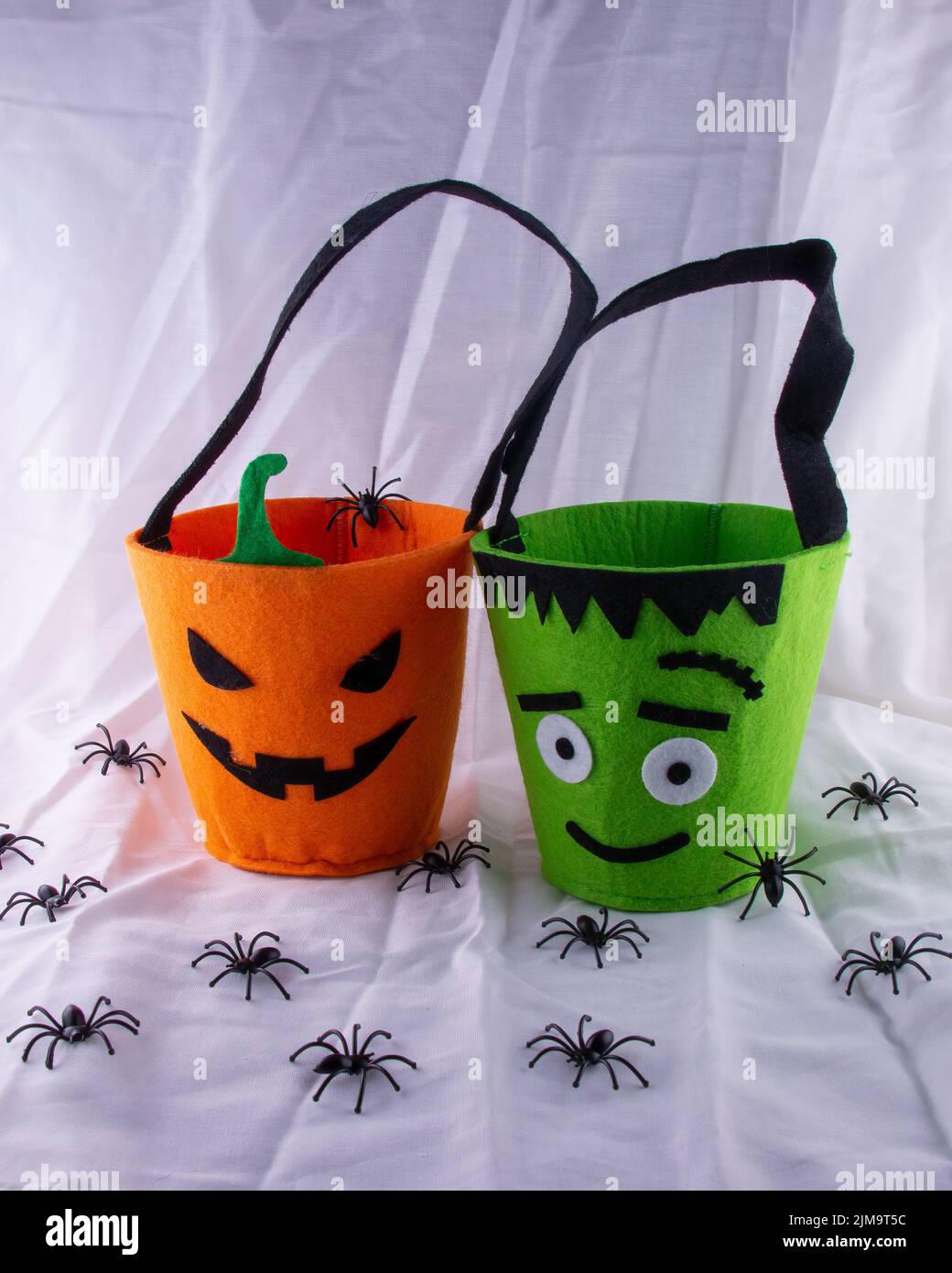 A vertical shot of orange pumpkin and green monster candy bags with ...