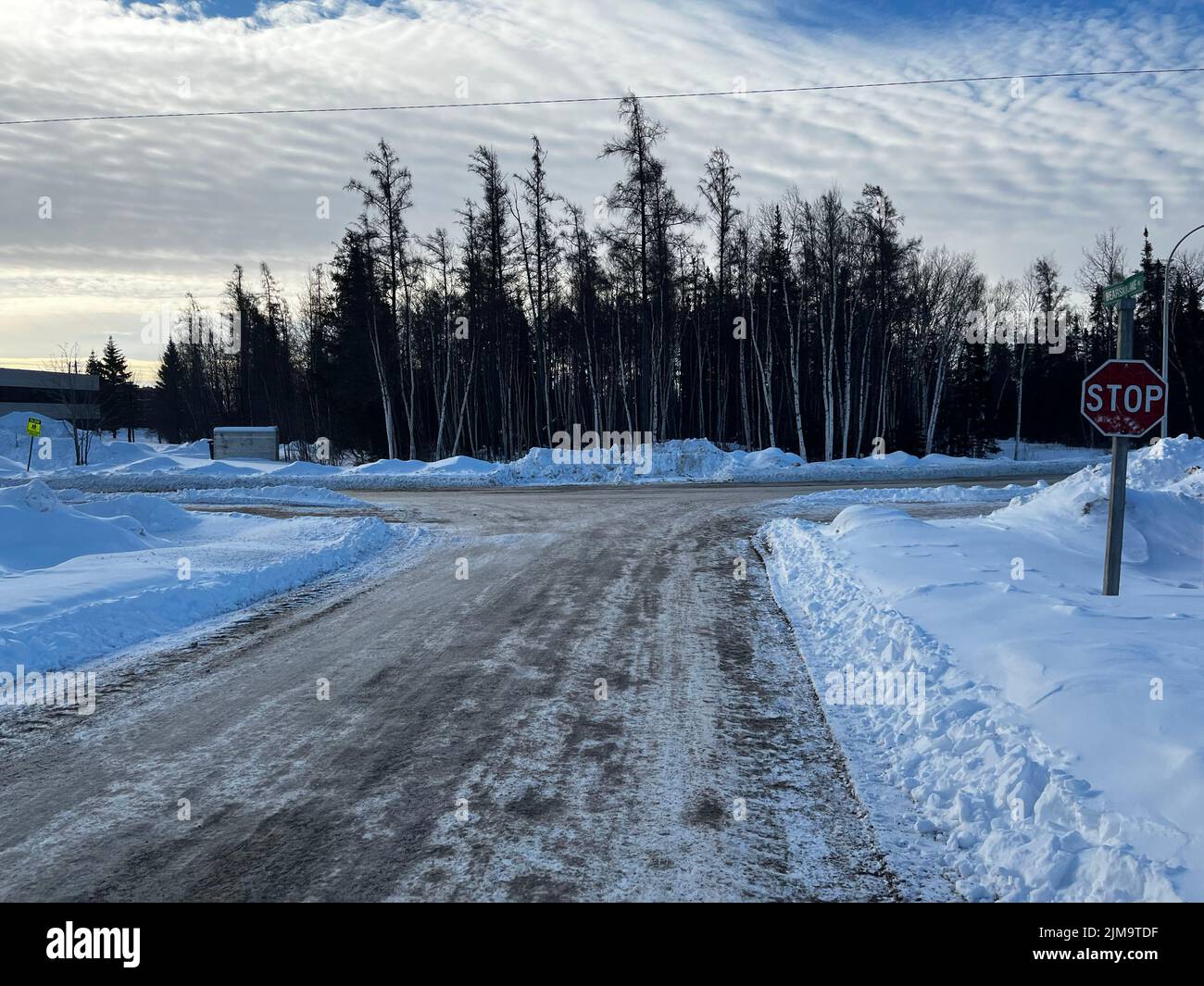 A beautiful shot of Y road intersection surrounded by snowy fields with ...