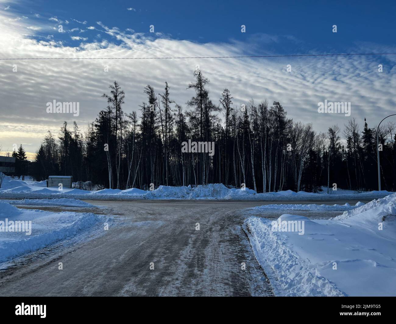 A beautiful shot of Y road intersection surrounded by snowy fields with ...