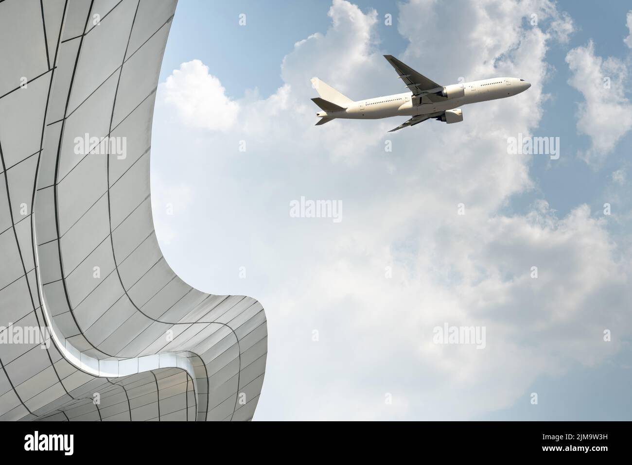 airplane fly in sky with edge of modern building and empty cloudy sky ...