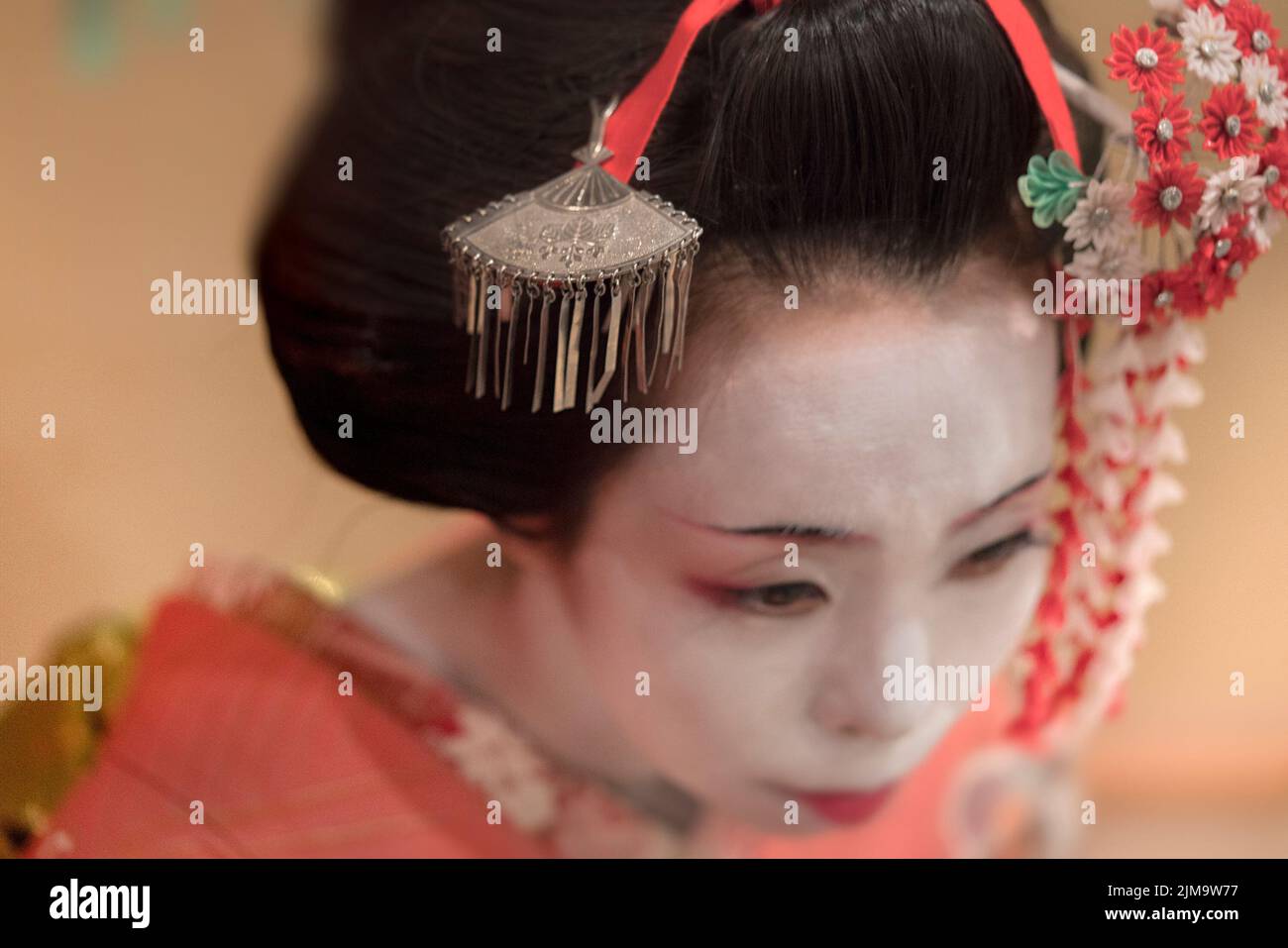 Japanese Maiko or geisha in red kimono coifed hair brooch with patterns ...