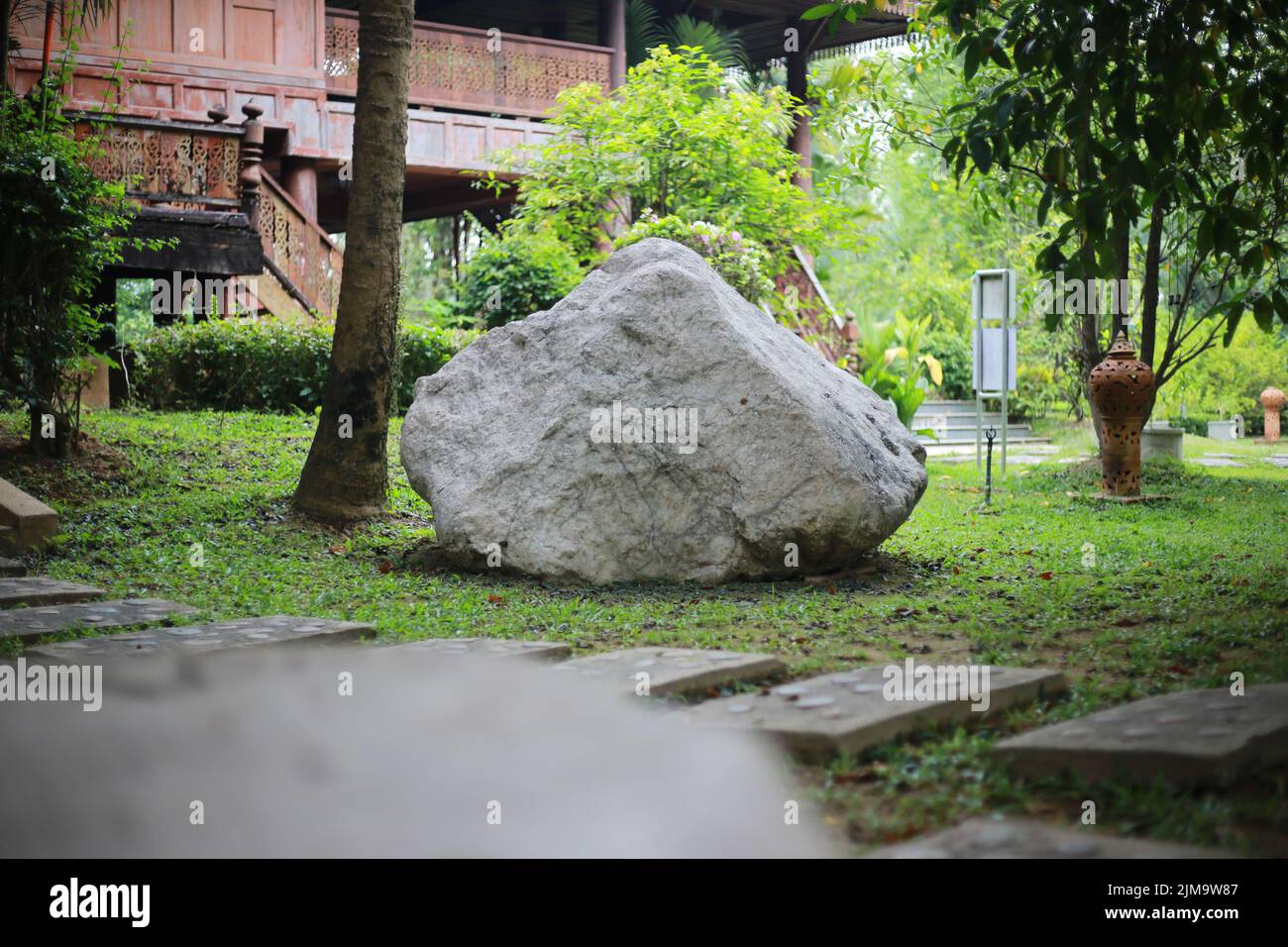 A view of a huge rock in a garden with trees on a sunny day Stock Photo ...