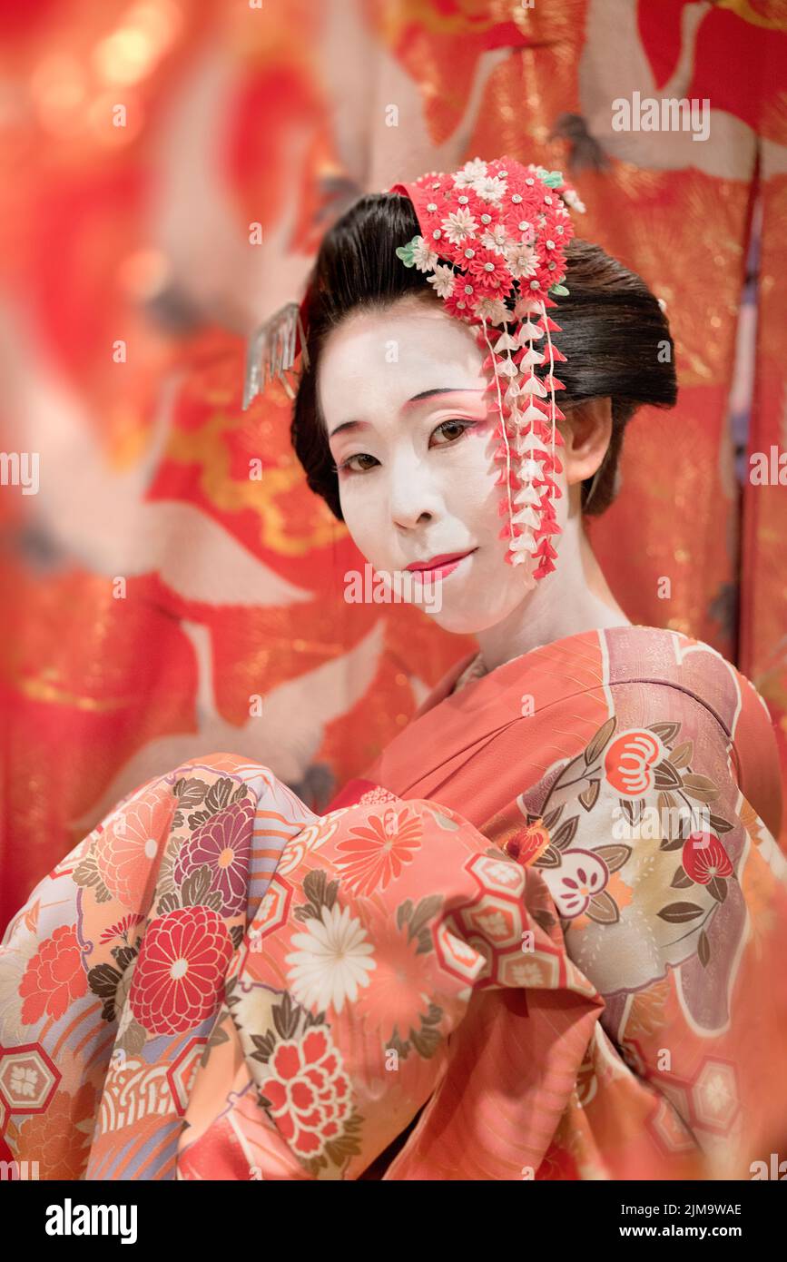 Japanese Maiko or geisha in red kimono coifed hair brooch with patterns ...