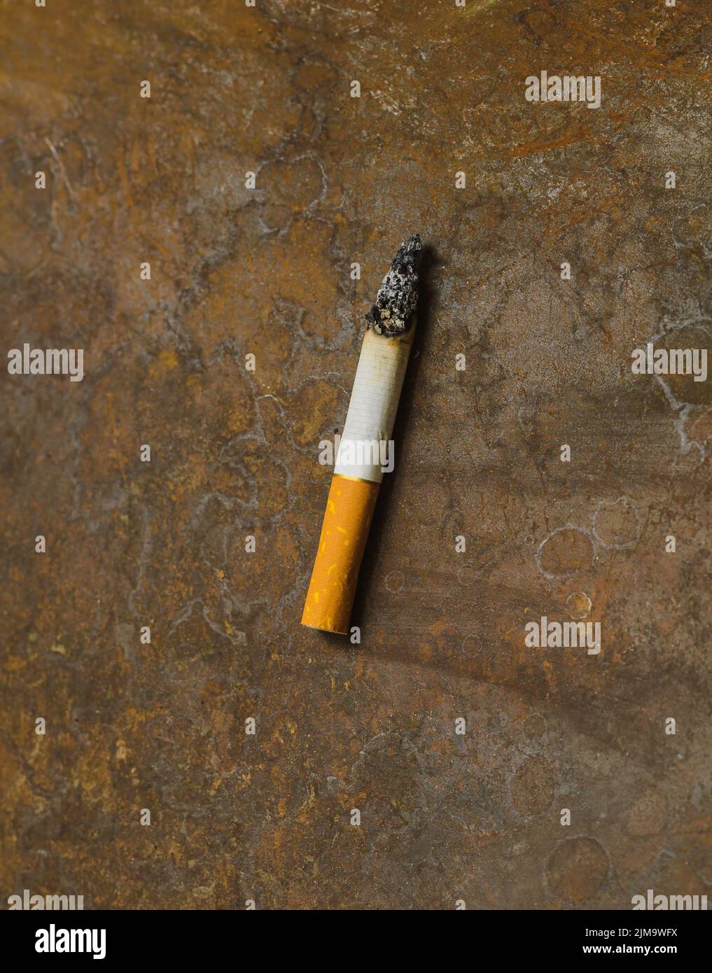 One used burned cigarette on rusty metal backgrounds Stock Photo - Alamy
