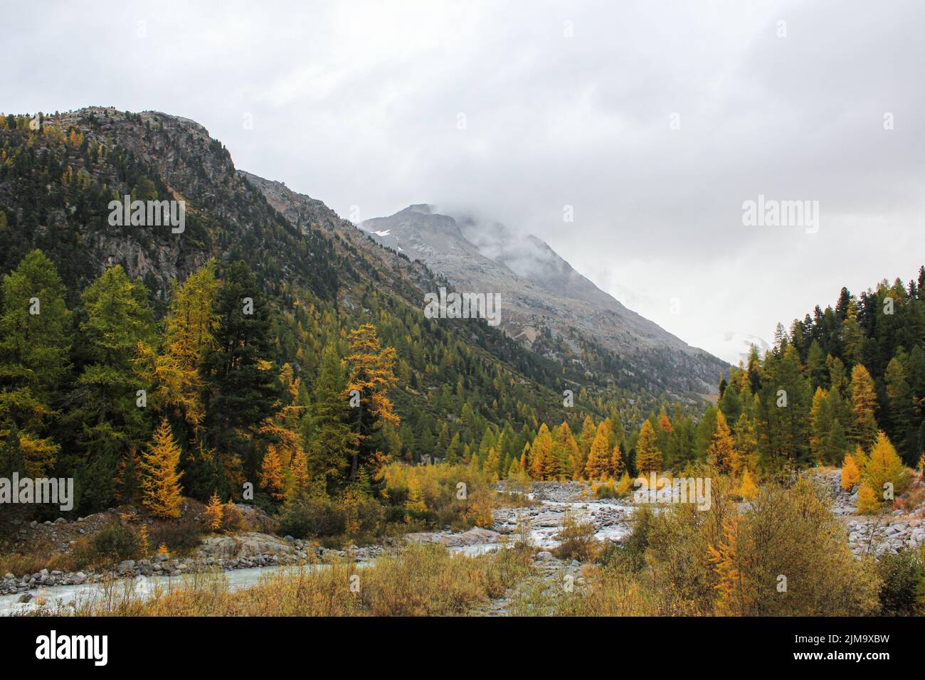 A beautiful view of a river flowing over rocks surrounded by colorful ...