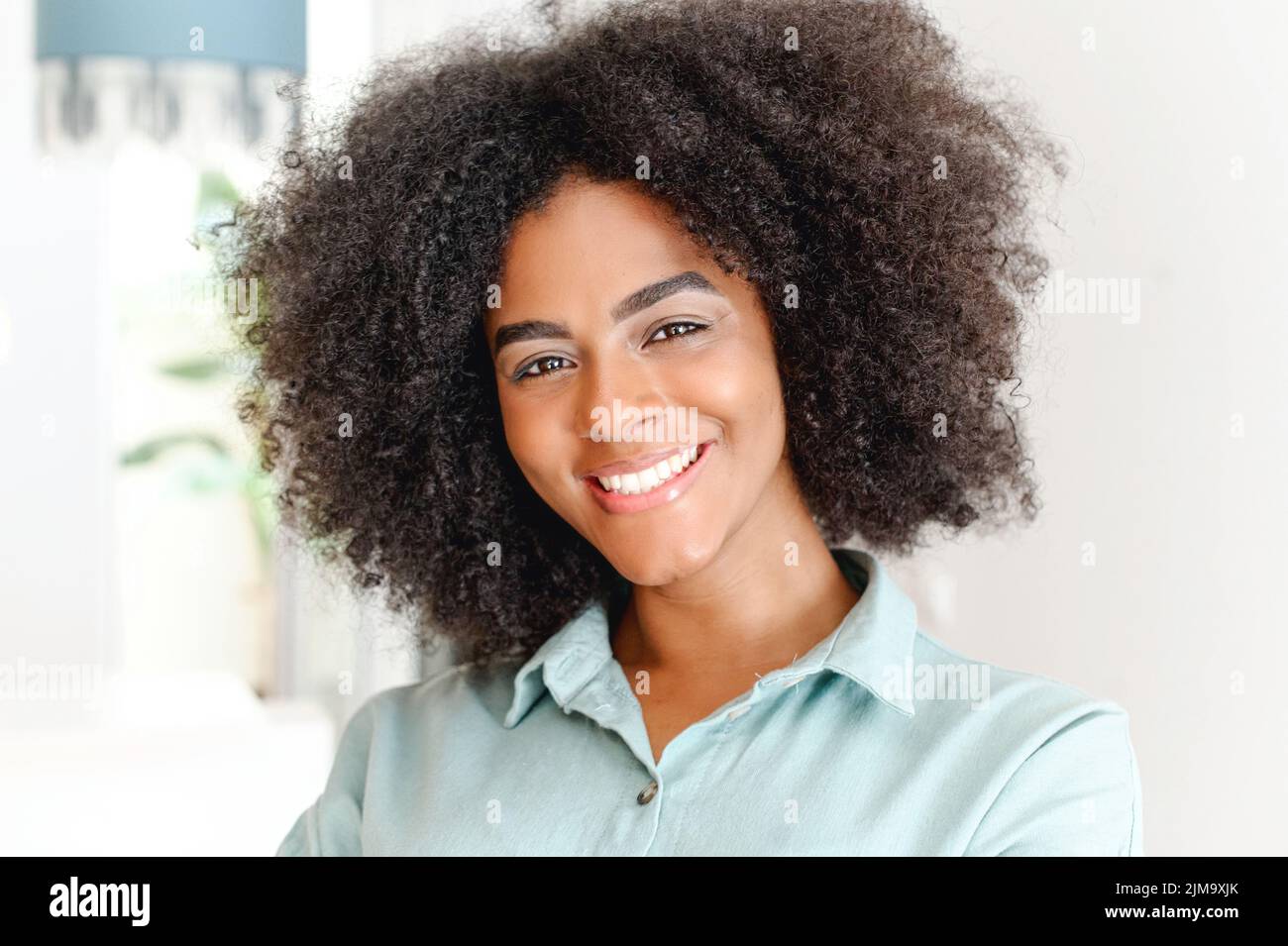 Headshot of a young African American ethnic female with Afro curly ...