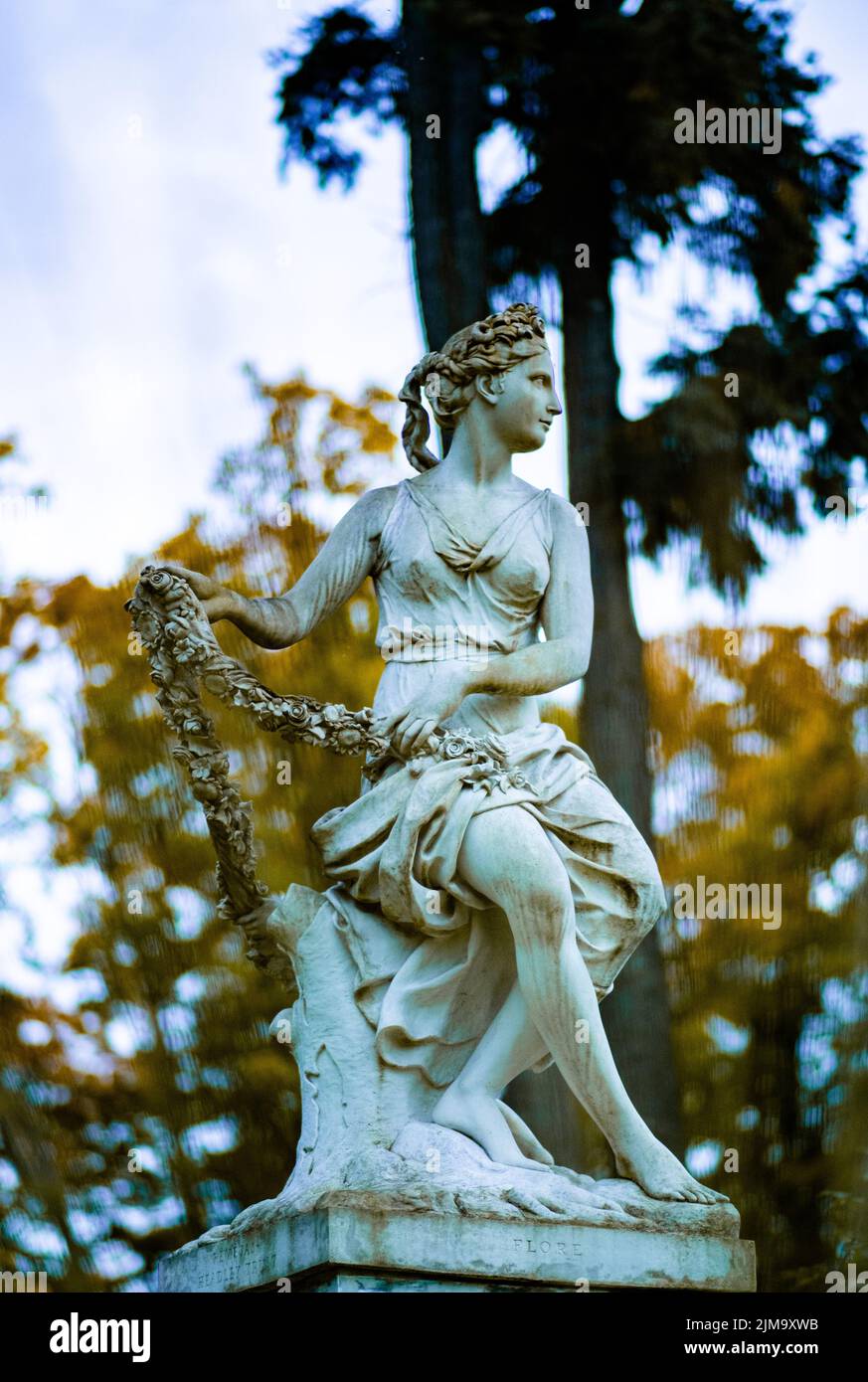 A vertical closeup shot of an aesthetic statue of a female in the park ...