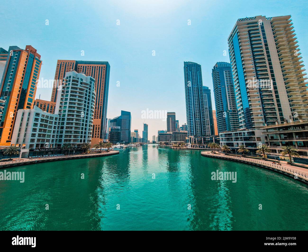 A high and tall building under a cloudy sky with a man made river at ...