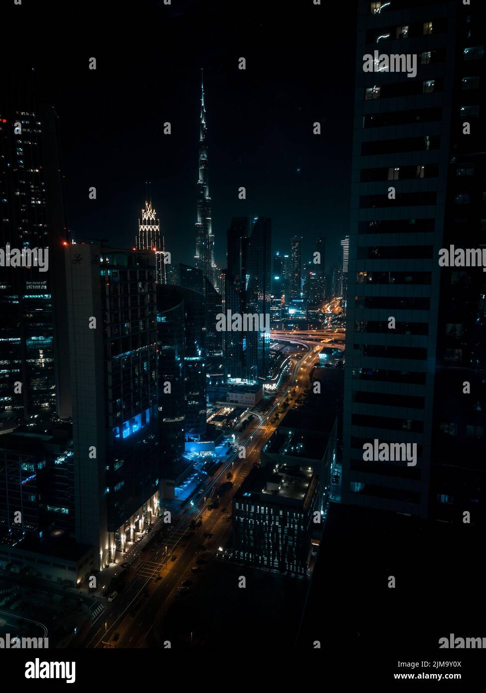 A high and tall building with city lights during night time Stock Photo ...