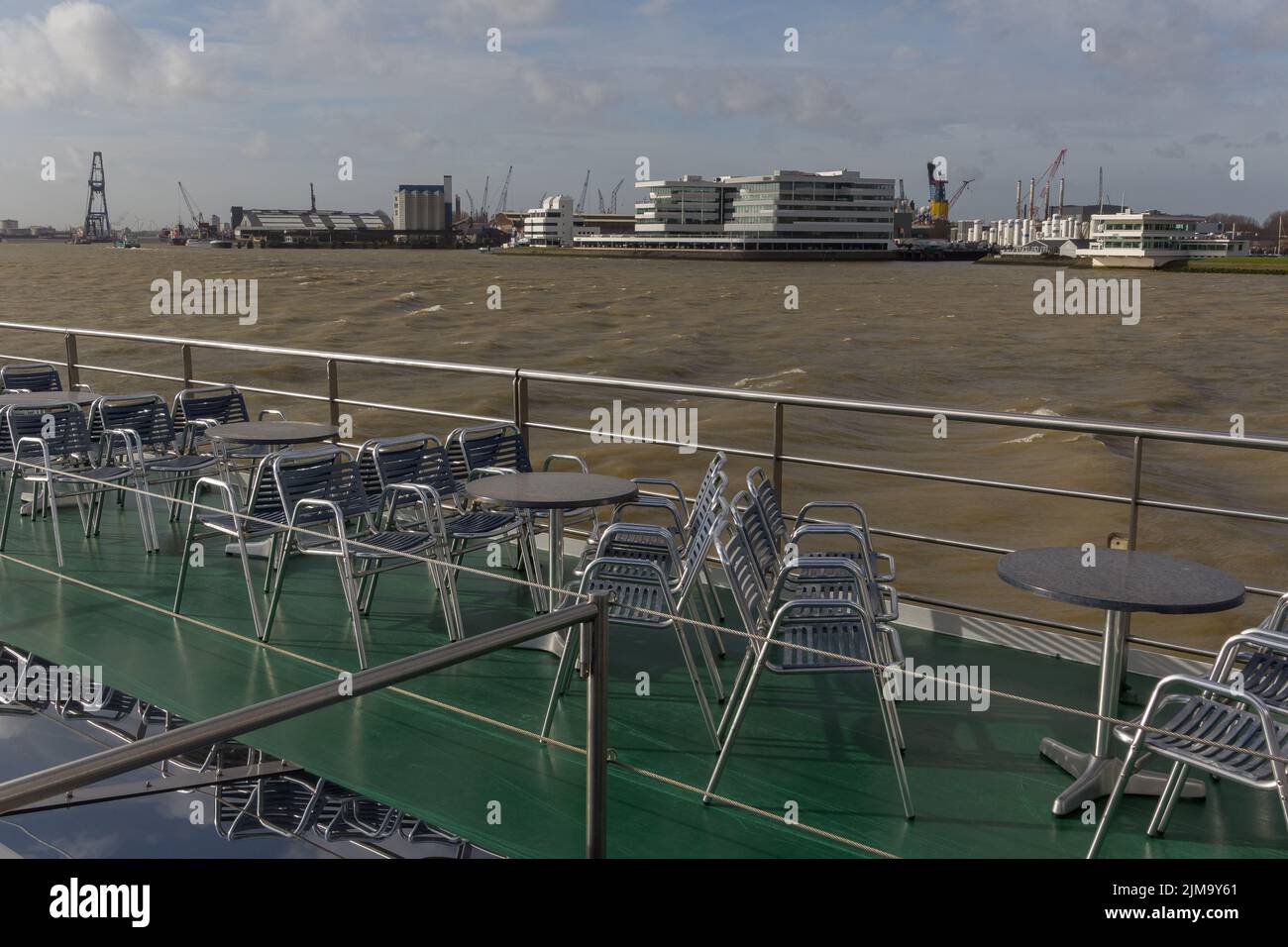 A canalside cafe with gray chairs and tables in Rotterdam, the ...
